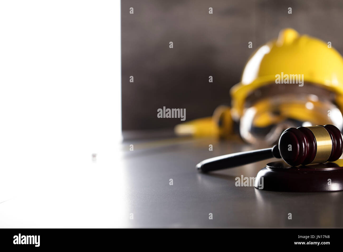 Construction law. Helmet and gavel. Stone table Stock Photo - Alamy