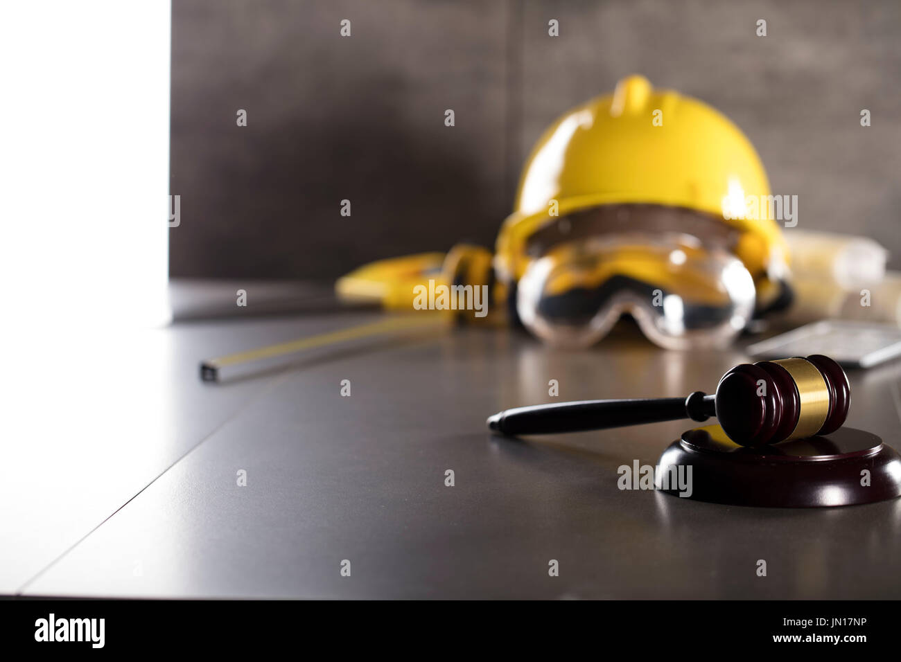 Construction law. Helmet and gavel. Stone table Stock Photo - Alamy