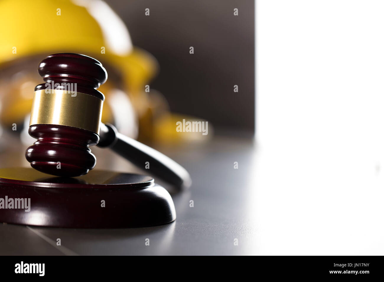Construction law. Helmet and gavel. Stone table Stock Photo - Alamy