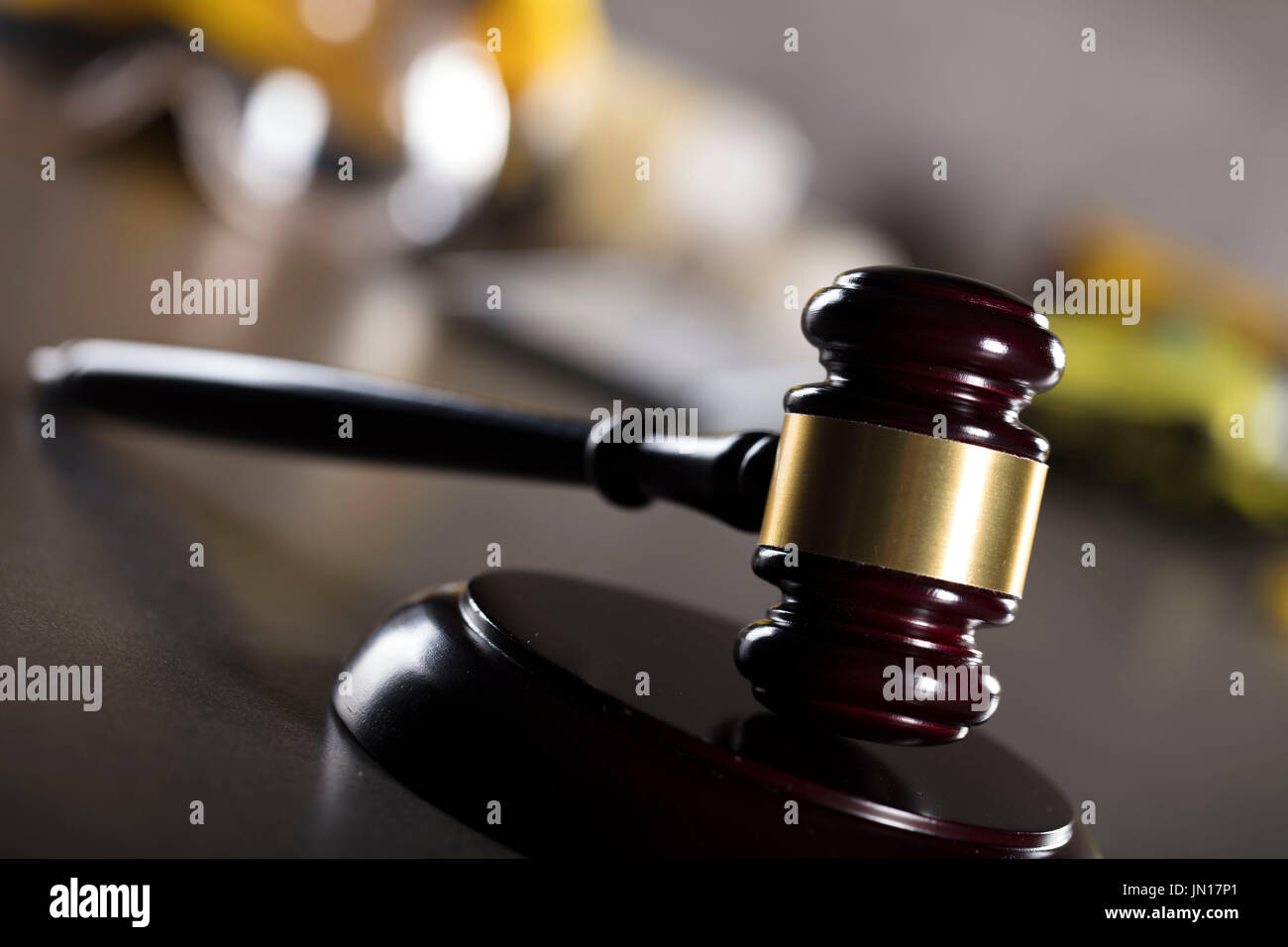 Construction law. Helmet and gavel. Stone table Stock Photo - Alamy