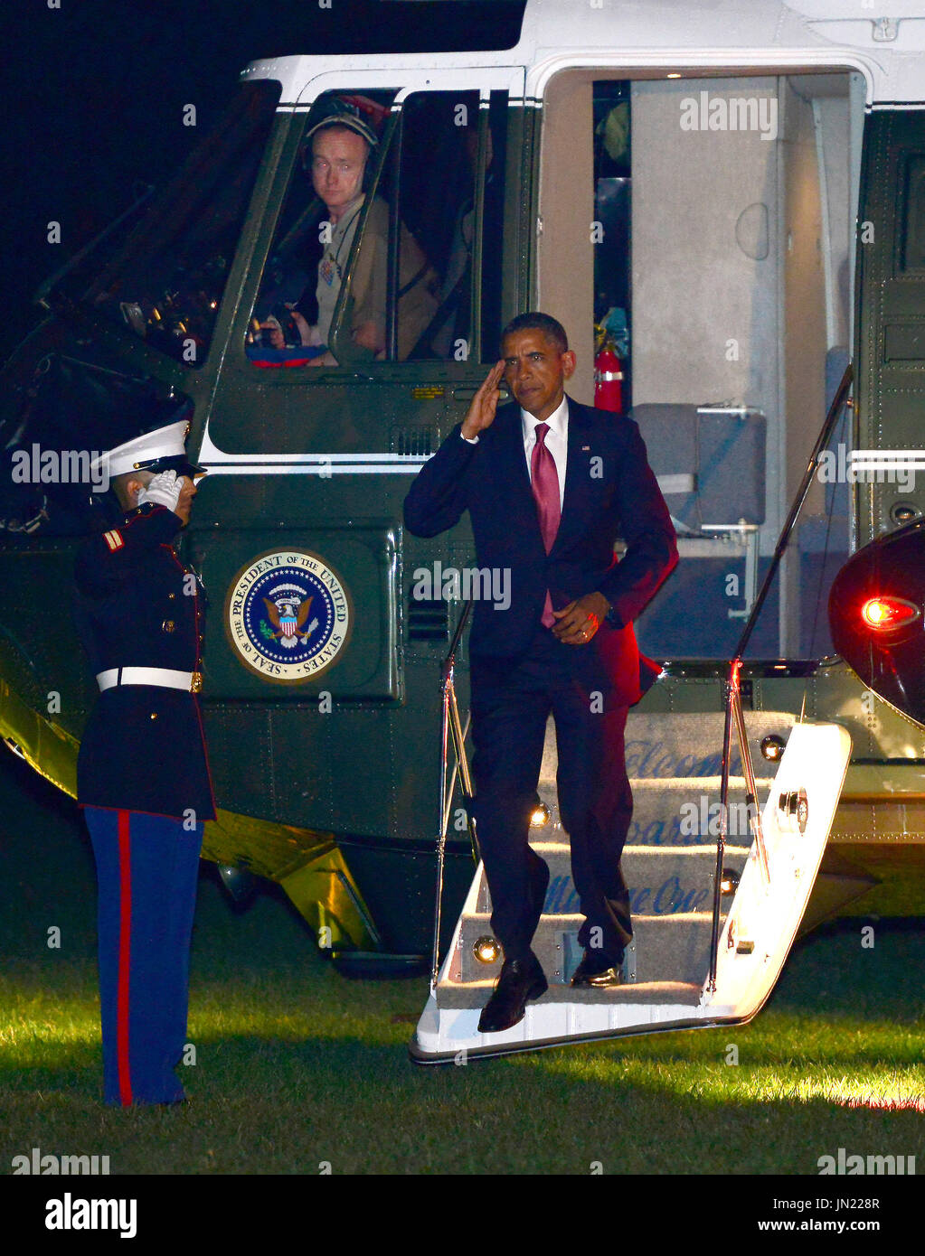 United States President Barack Obama salutes the Marine Guard as he ...