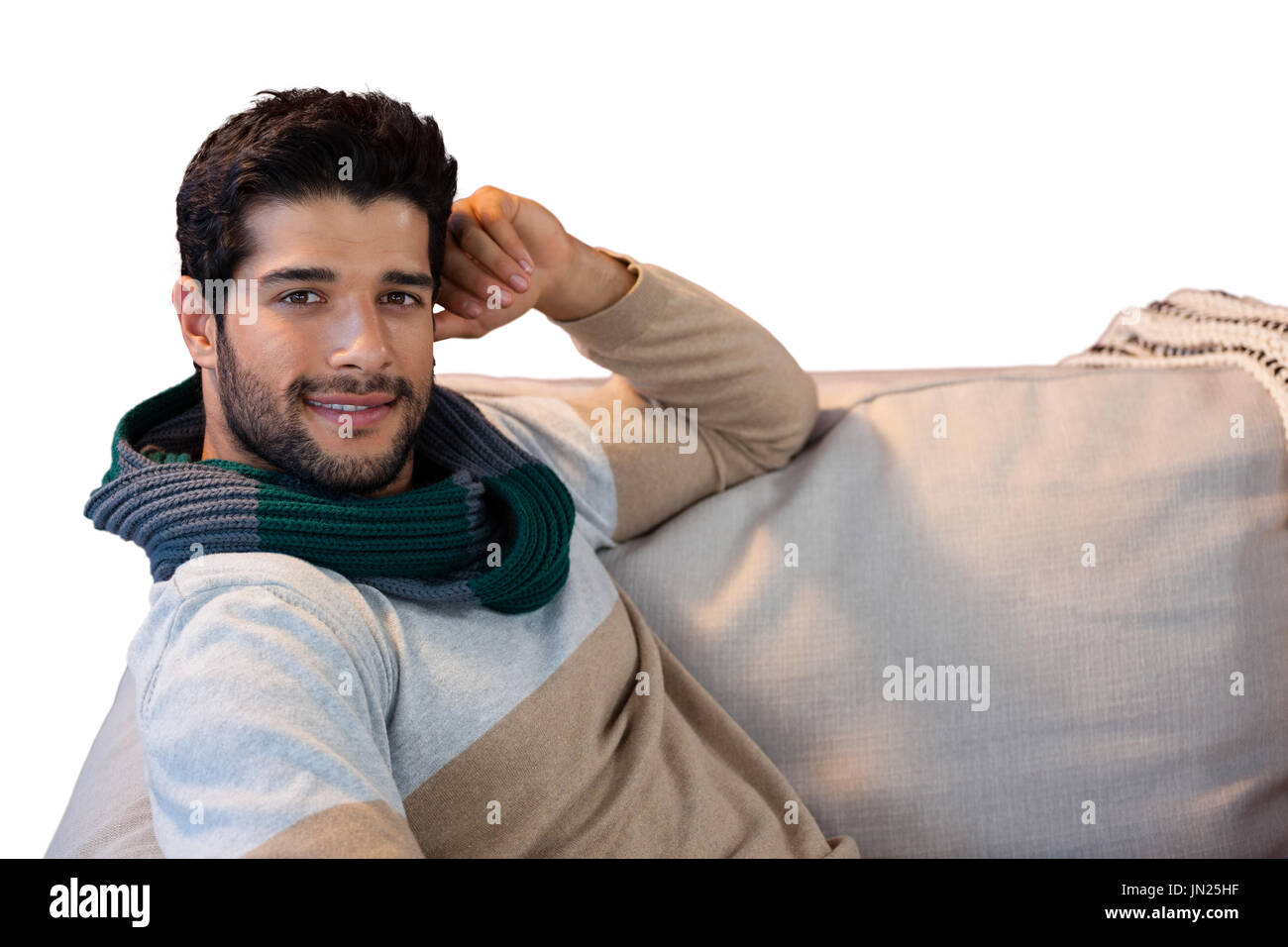 Portrait of smiling man relaxing on sofa against white background Stock ...