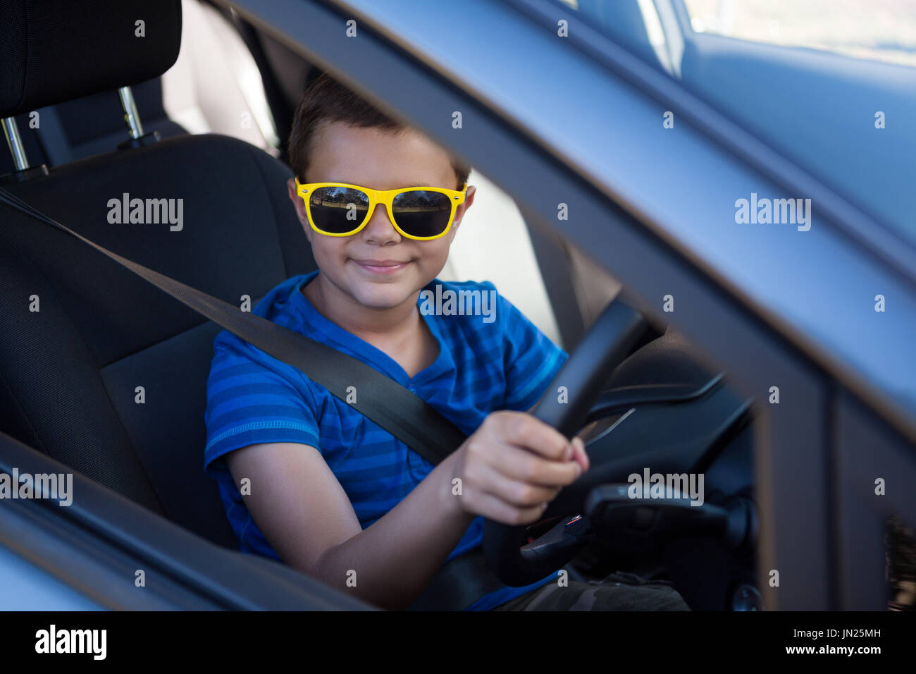 Smiling teenage boy driving a car Stock Photo - Alamy