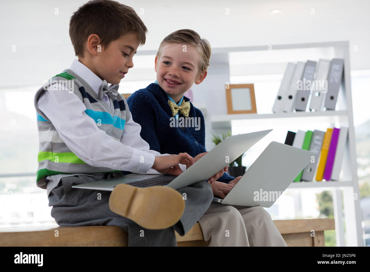 Kids as business executives using laptop while sitting on table in ...
