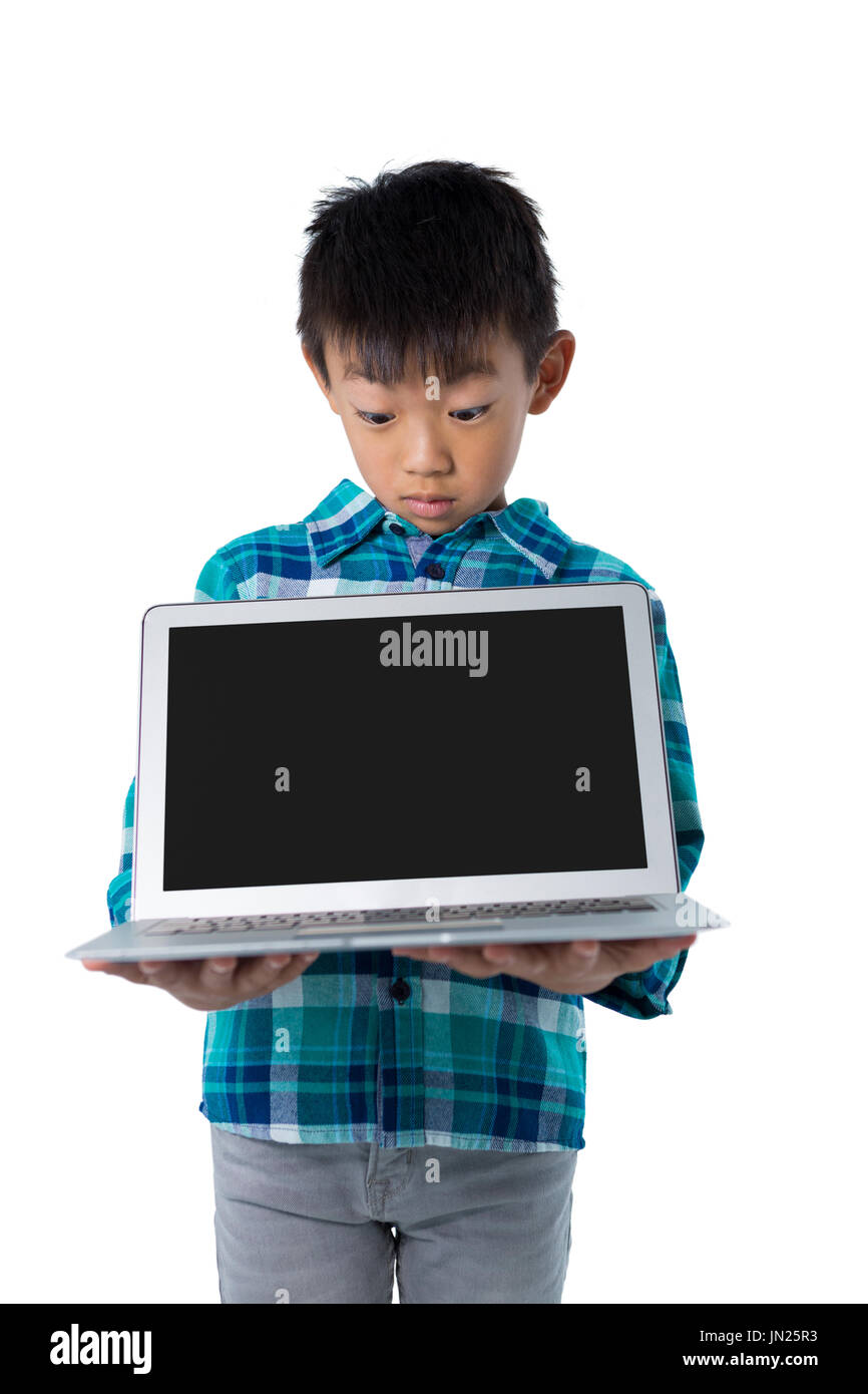 Boy holding laptop against white background Stock Photo - Alamy