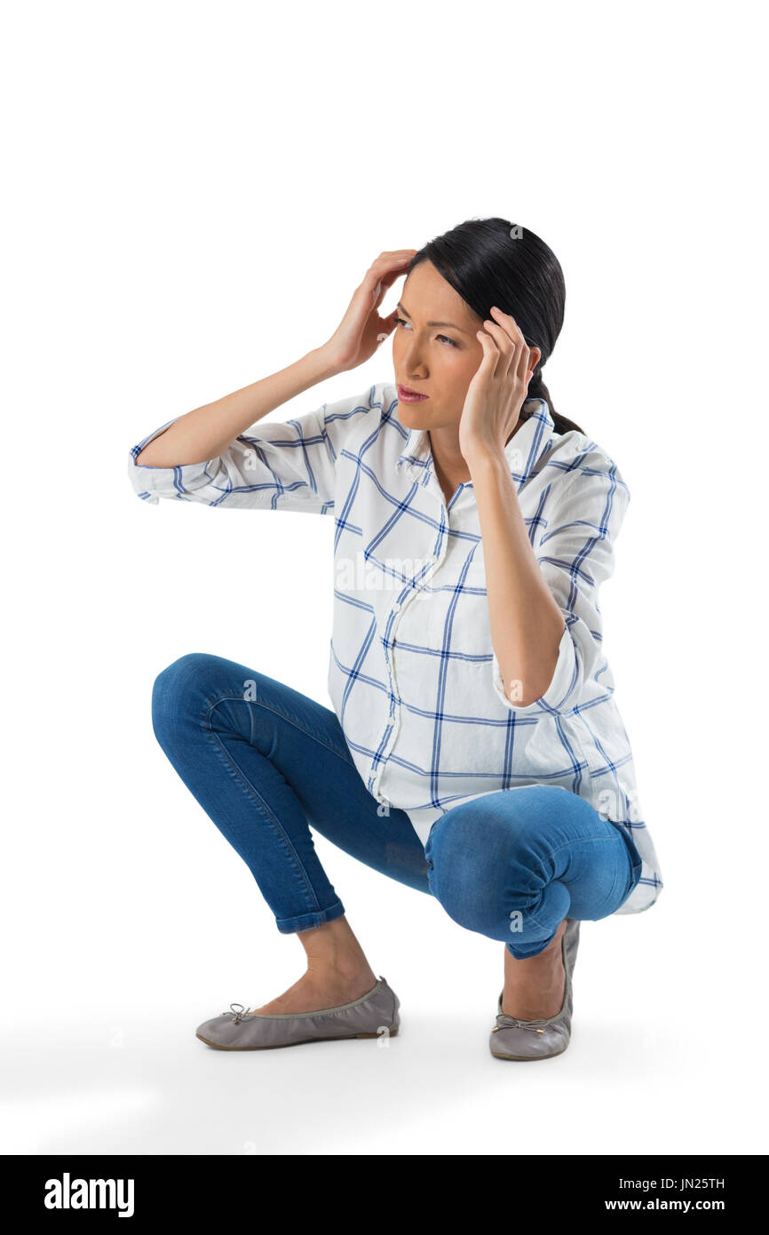Sad woman crouching against white background Stock Photo - Alamy