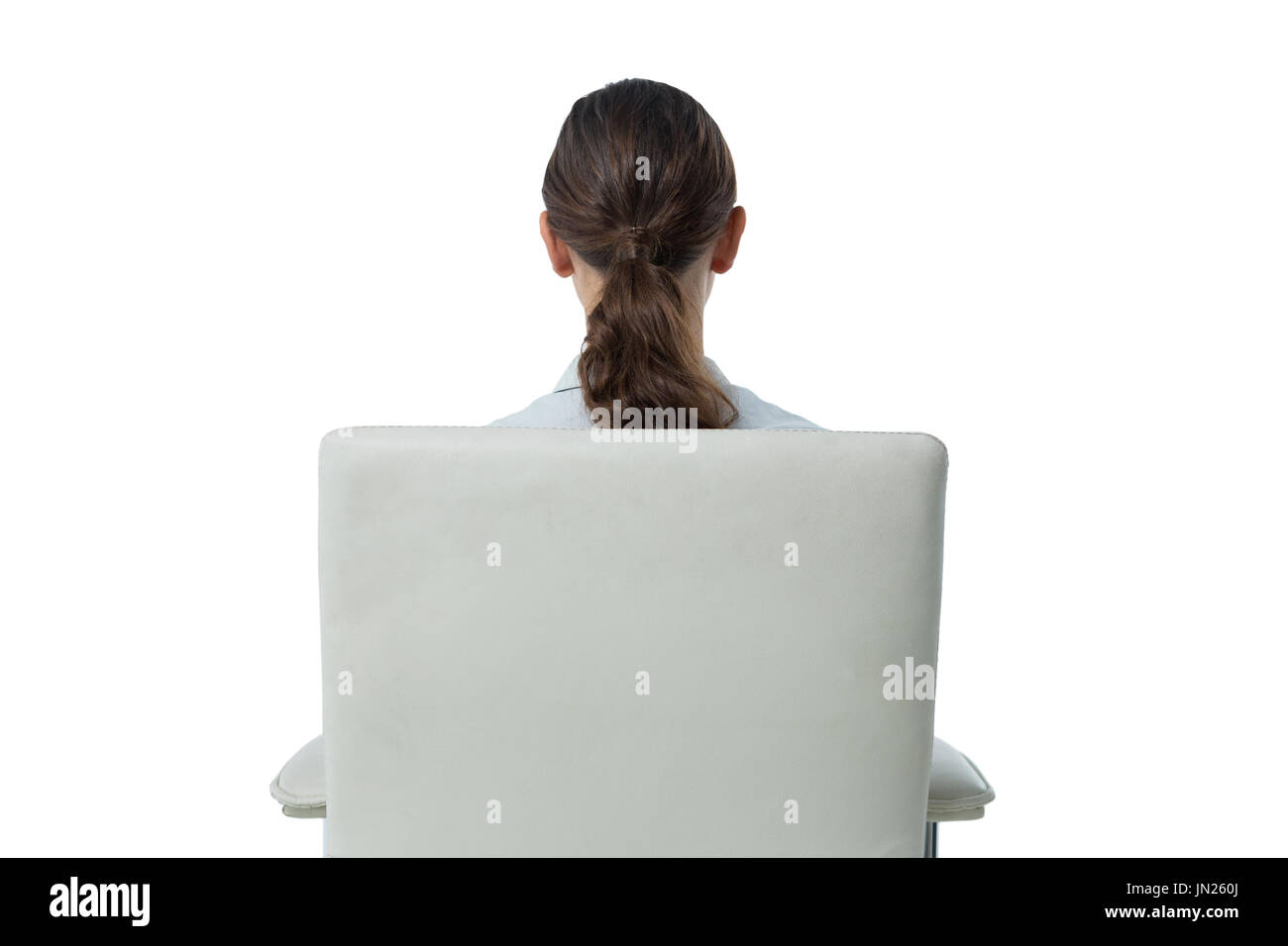 Rear view of female executive relaxing on chair against white ...