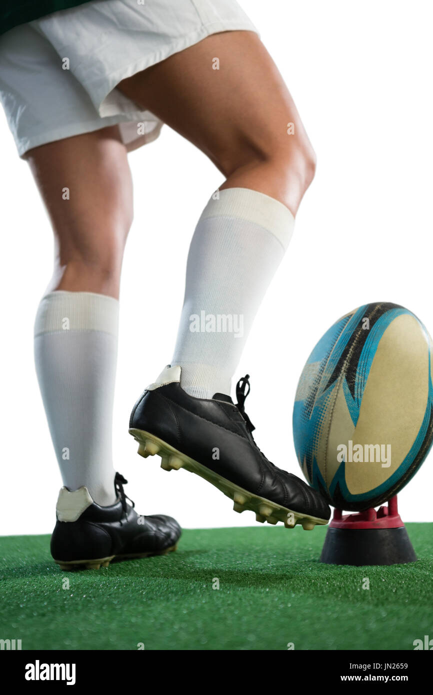 Low section of female rugby player kicking ball on tee while playing ...