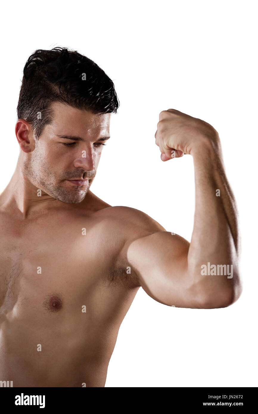 Shirtless American football player flexing muscles against white ...