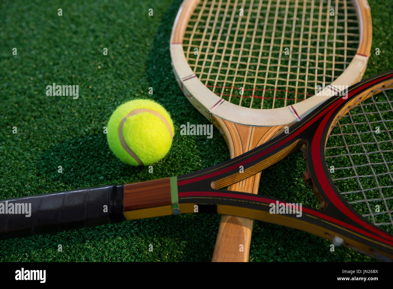 Close up of wooden racket with tennis ball on field Stock Photo - Alamy