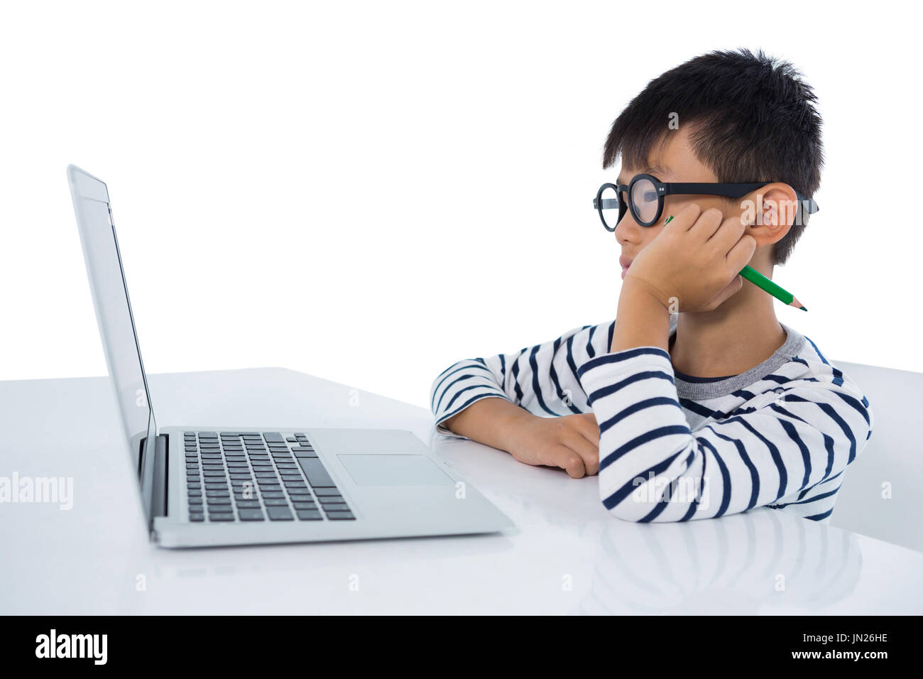 Thoughtful boy sitting with laptop against white background Stock Photo ...