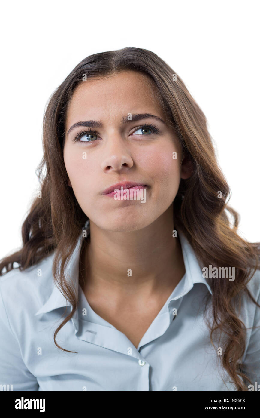 Confused female executive standing against white background Stock Photo ...