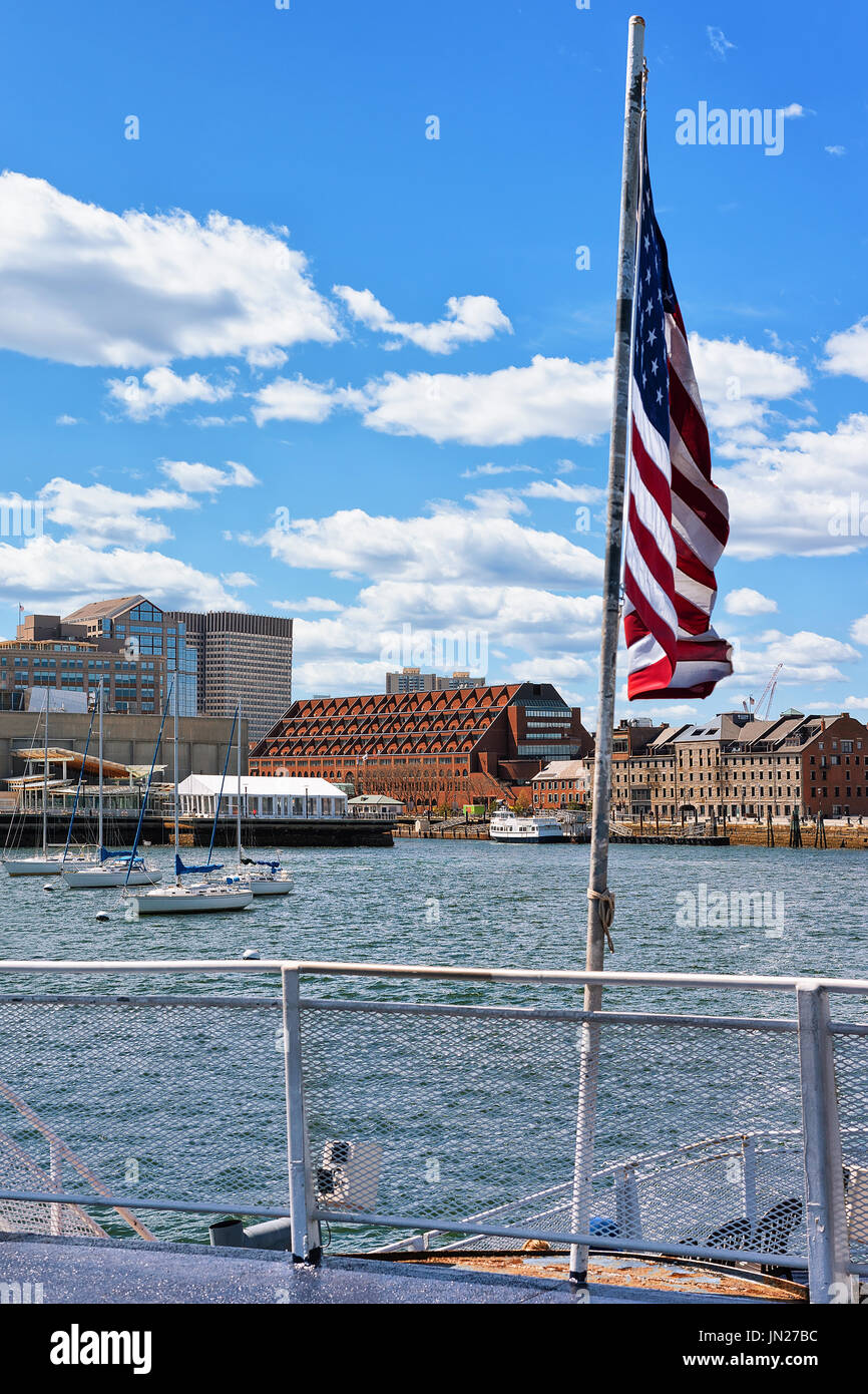 Beautiful city waterfront and skyline and US flag in Boston, MA ...