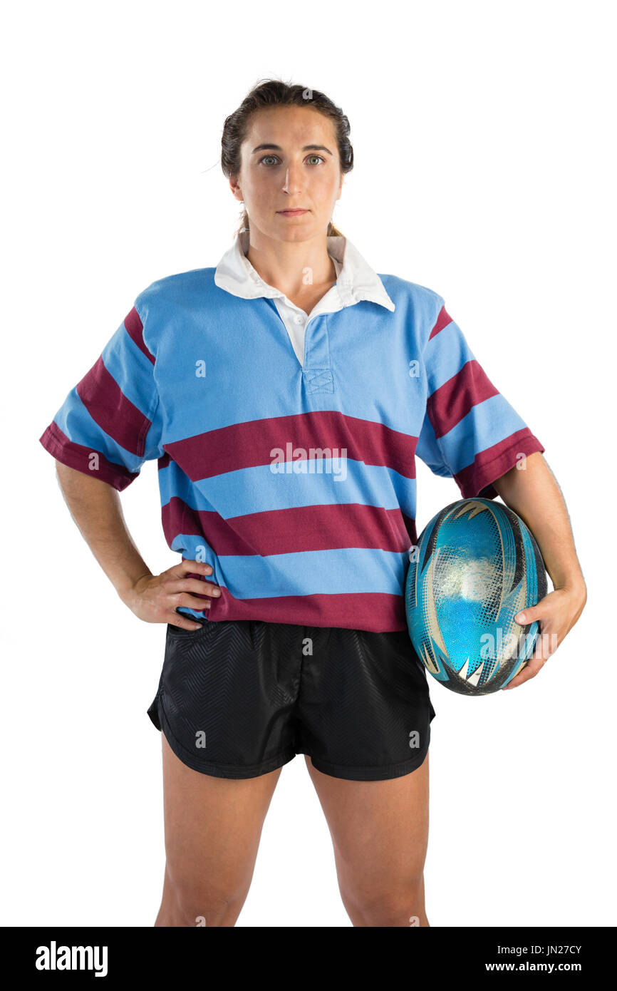 Portrait of confident female athlete with hand on hip holding rugby ... Portrait of confident female athlete with hand on hip holding rugby ...