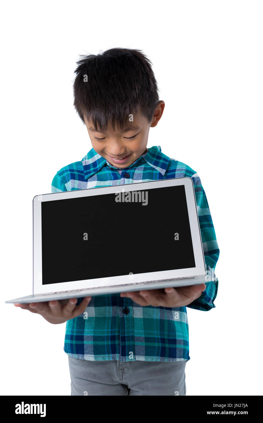 Smiling boy holding laptop against white background Stock Photo - Alamy