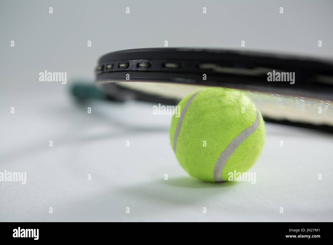 Close up of racket on tennis ball against white background Stock Photo ...