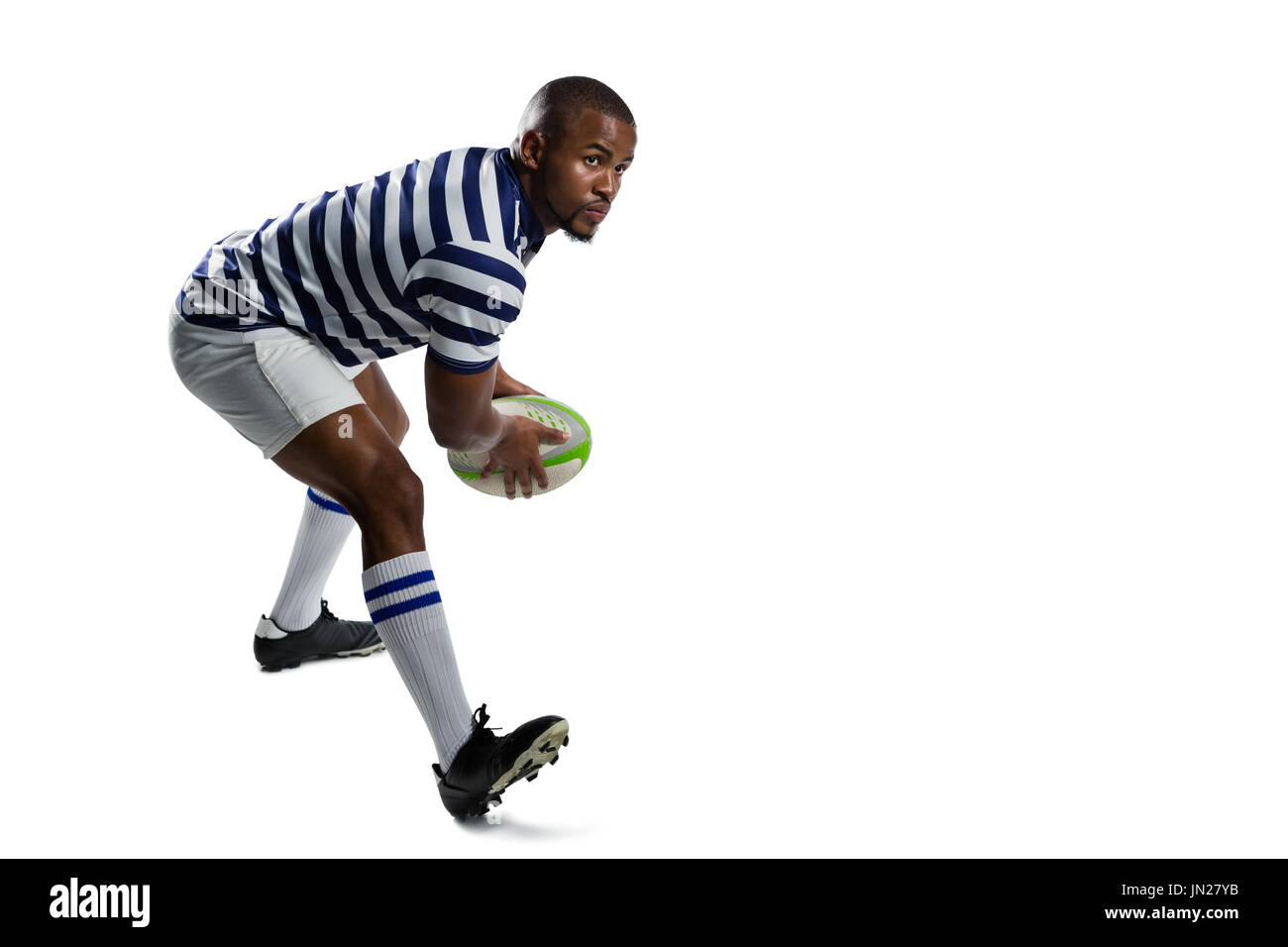 Full length of young athlete playing rugby against white background ...