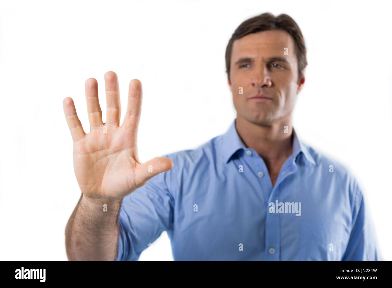 Male executive showing stop sign against white background Stock Photo ...