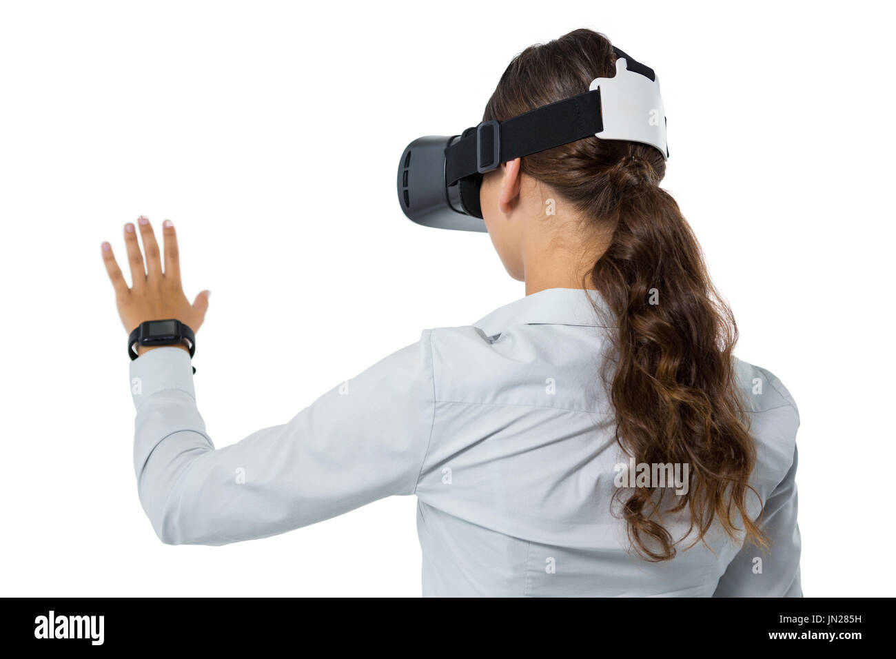 Female executive using virtual reality headset against white background ...