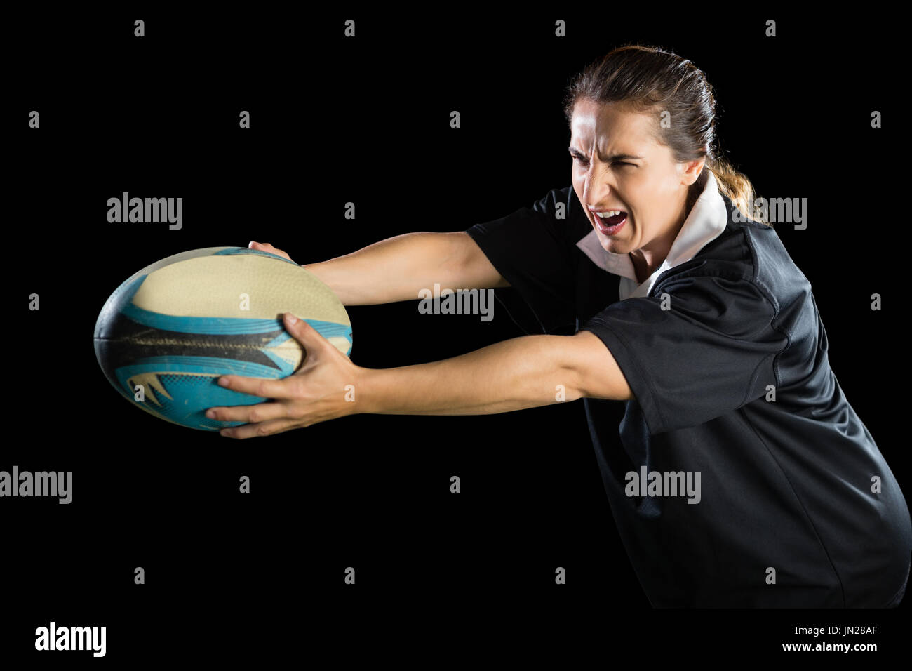Female athlete playing rugby against black background Stock Photo - Alamy