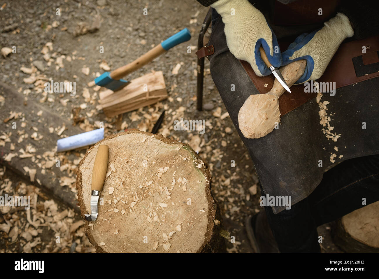 Mid section of carpenter making wooden spoon in workshop Stock Photo ...