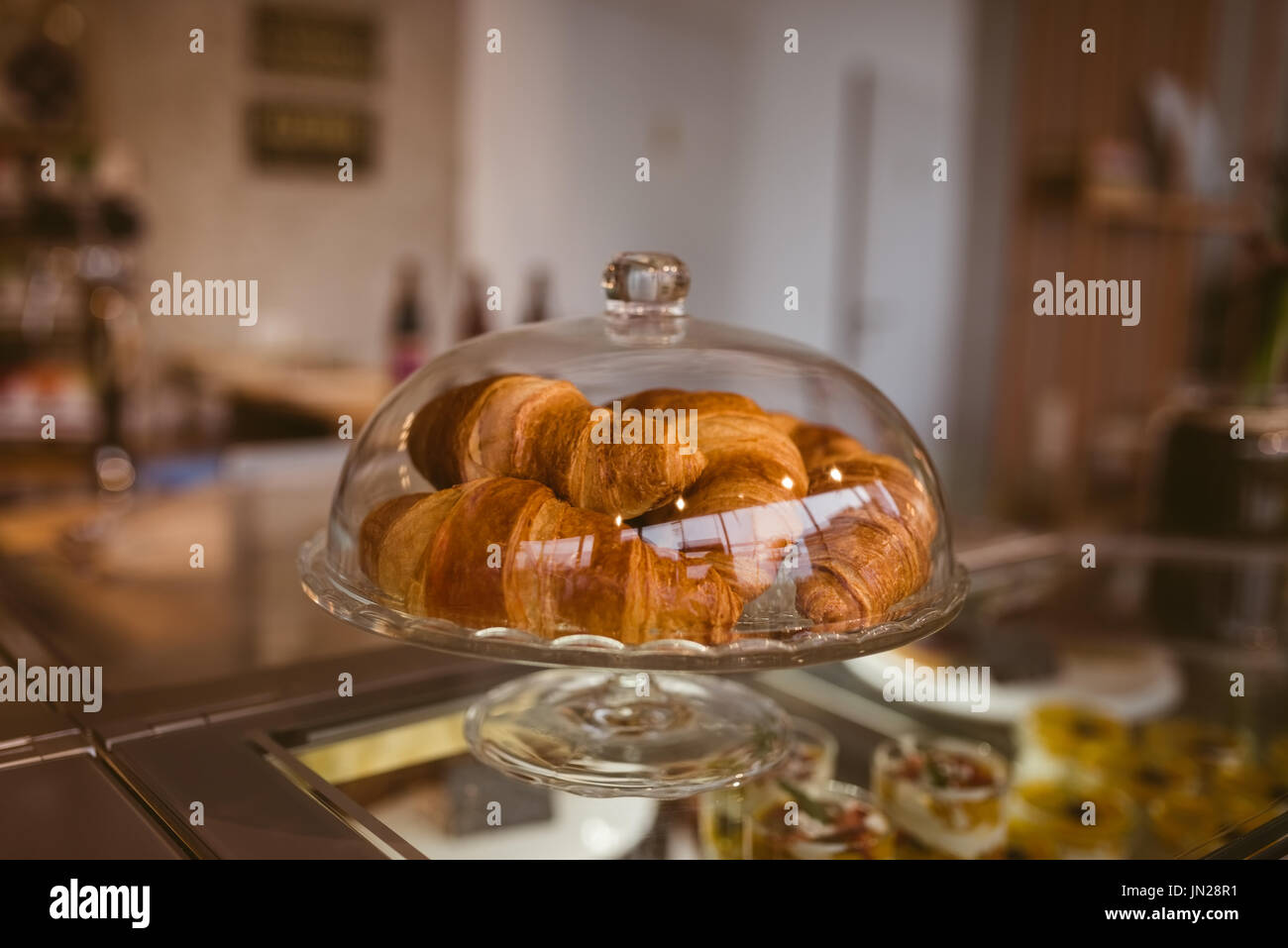 Croissant in glass container on cafe counter Stock Photo - Alamy