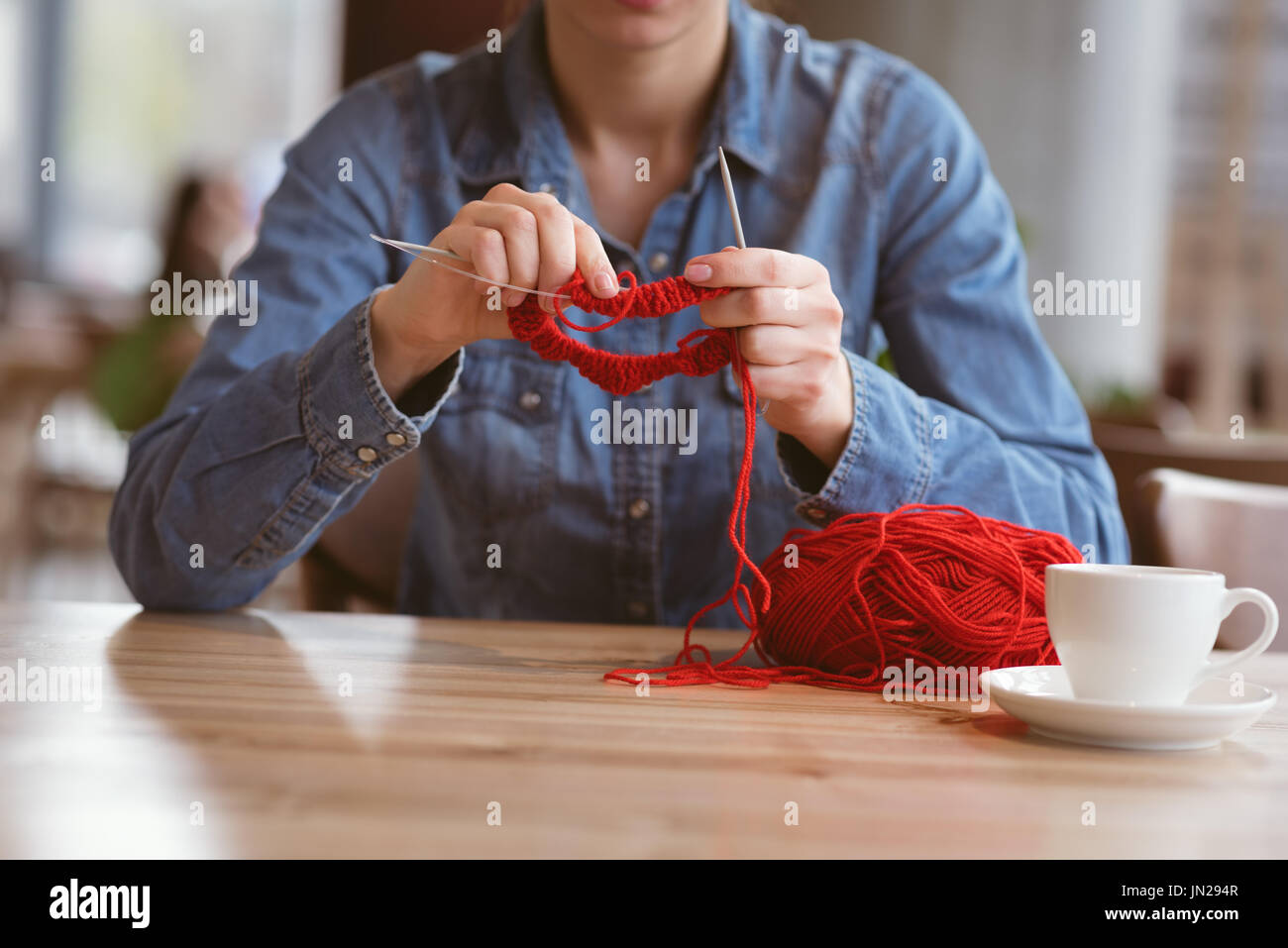 Mid-section of woman knitting while sitting in cafe Stock Photo - Alamy