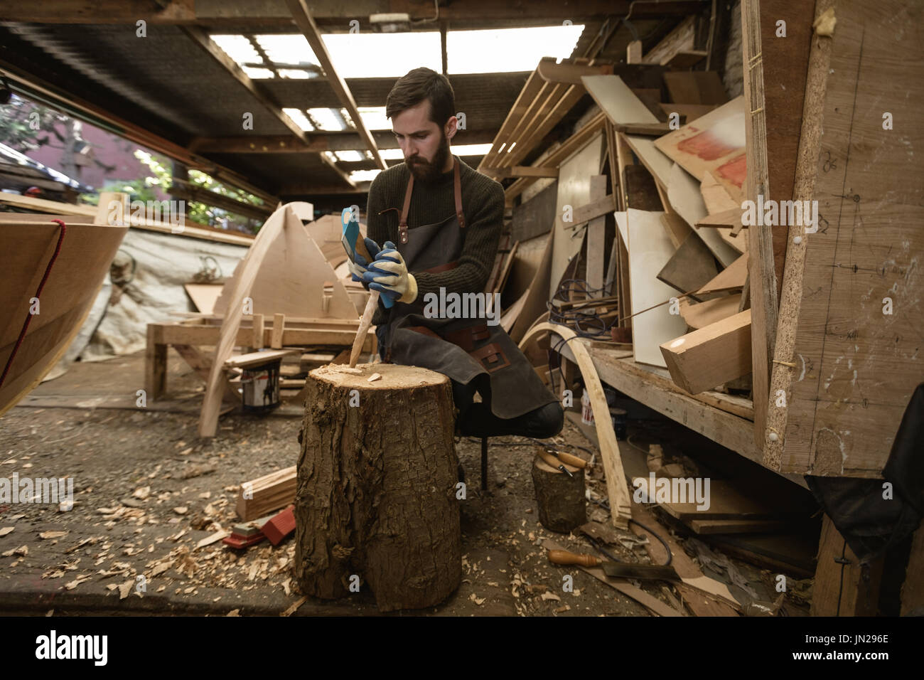 Carpenter cutting wooden log in workshop Stock Photo - Alamy
