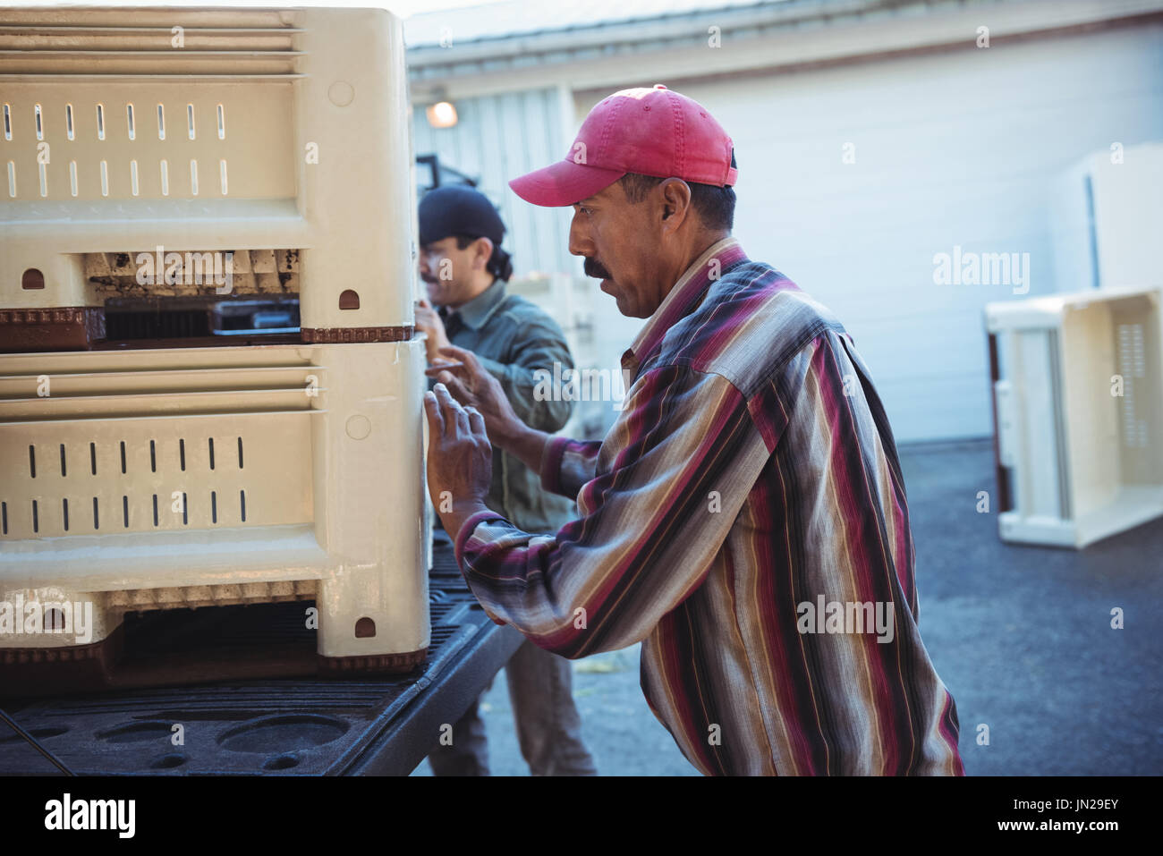 Farmers loading fruit containers in truck at farm house Stock Photo - Alamy