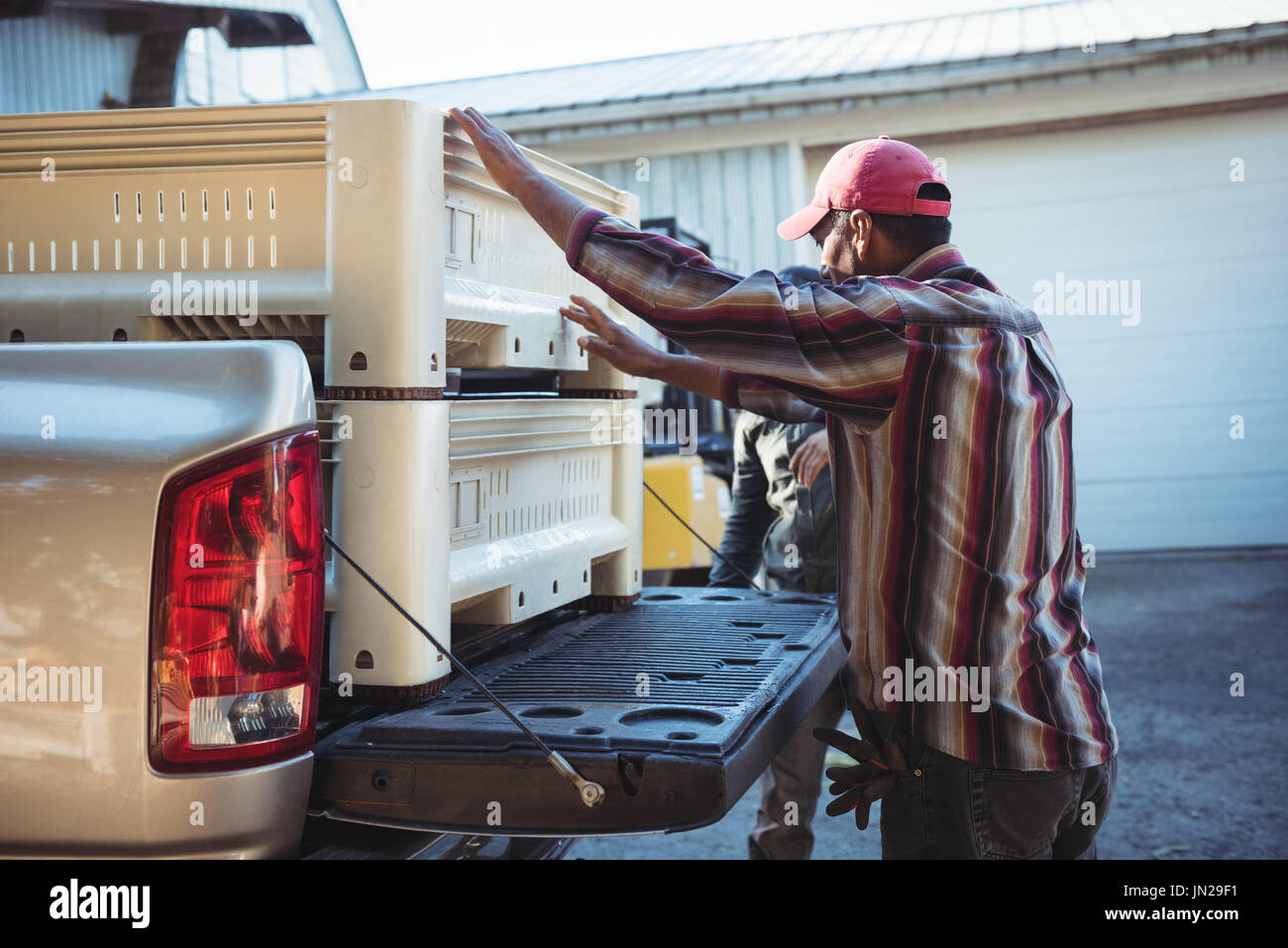 Farmers loading fruit containers in truck at farm house Stock Photo - Alamy