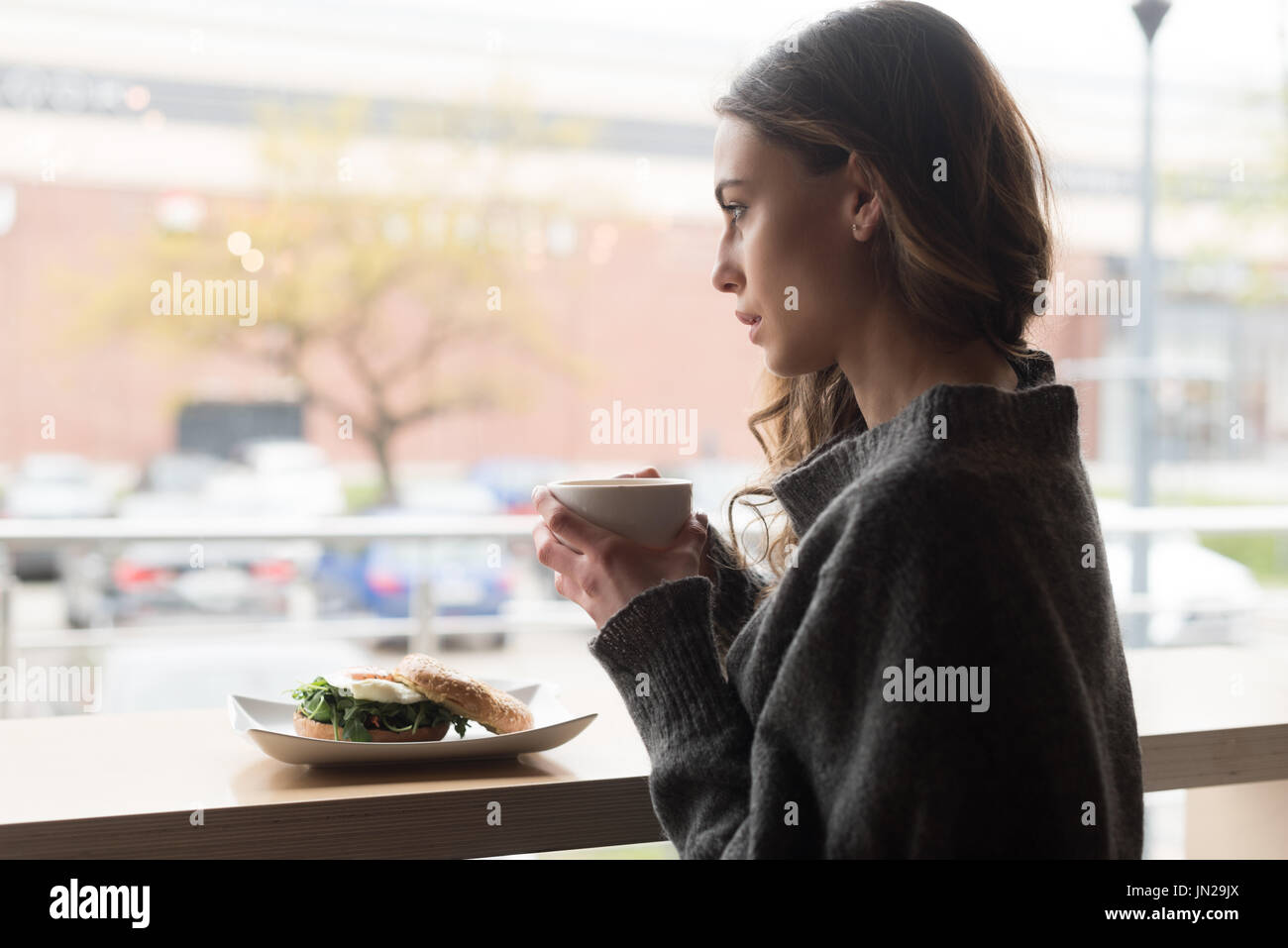 Side view of thoughtful woman having coffee in cafe Stock Photo - Alamy