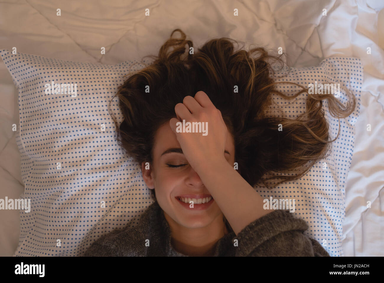 Overhead view cheerful woman on bed at home Stock Photo - Alamy