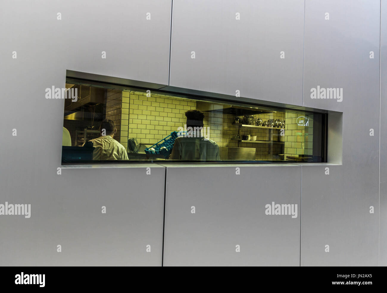 Restaurant kitchen interior seen through a long rectangular window ...
