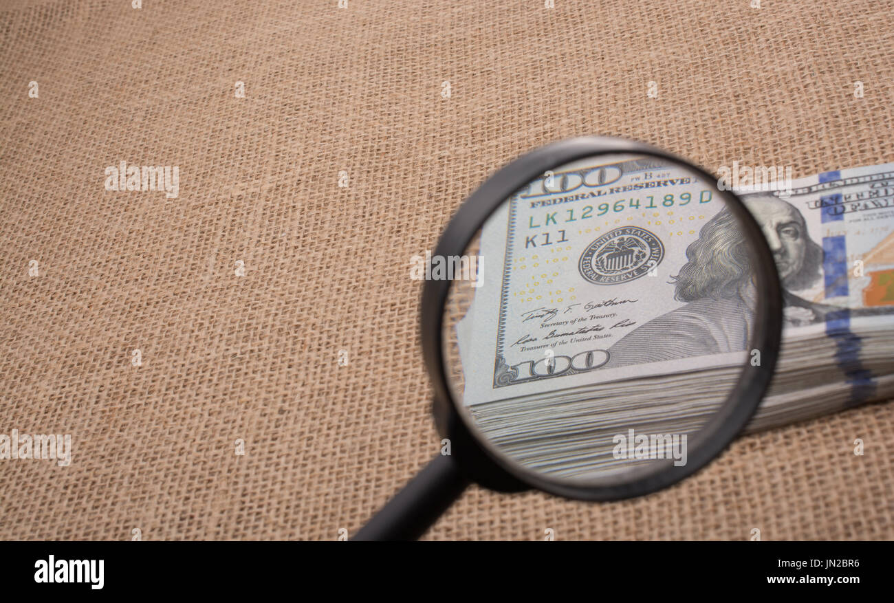 Magnifying glass over the banknote bundle of US dollar Stock Photo - Alamy