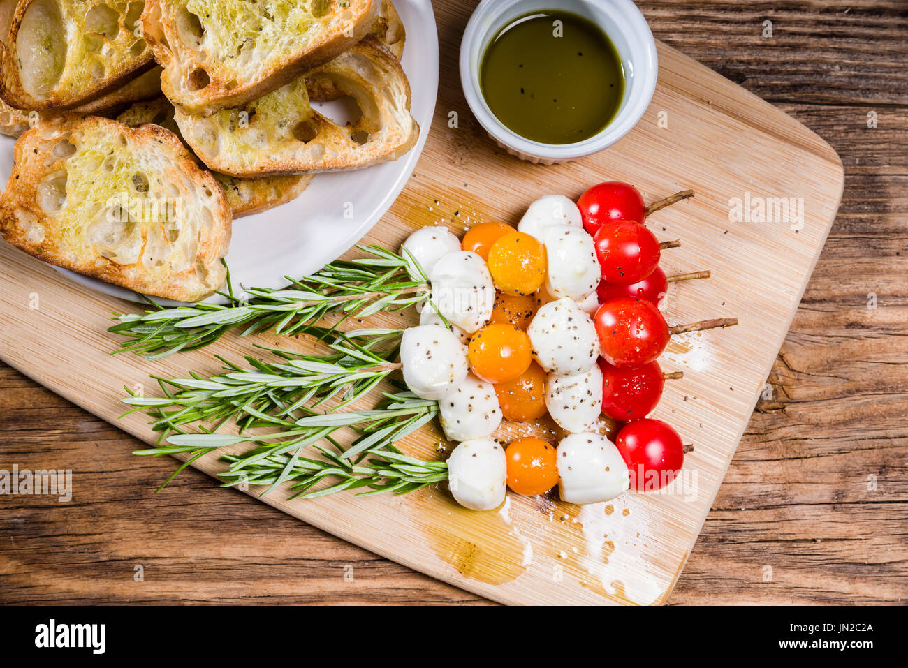 Tomato cheese and bread appetizers on rosemary skewers Stock Photo - Alamy