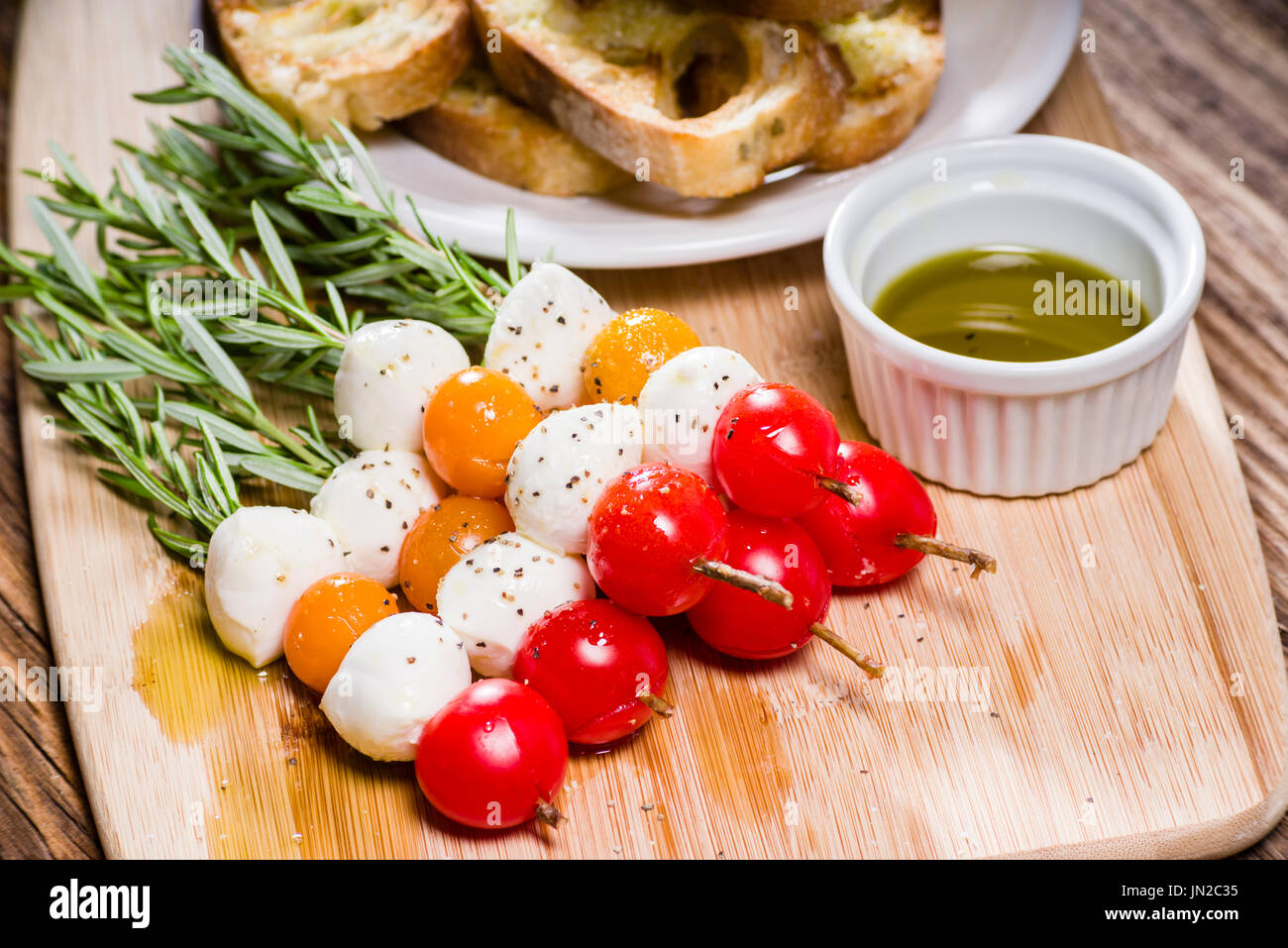 Tomato cheese and bread appetizers on rosemary skewers Stock Photo - Alamy