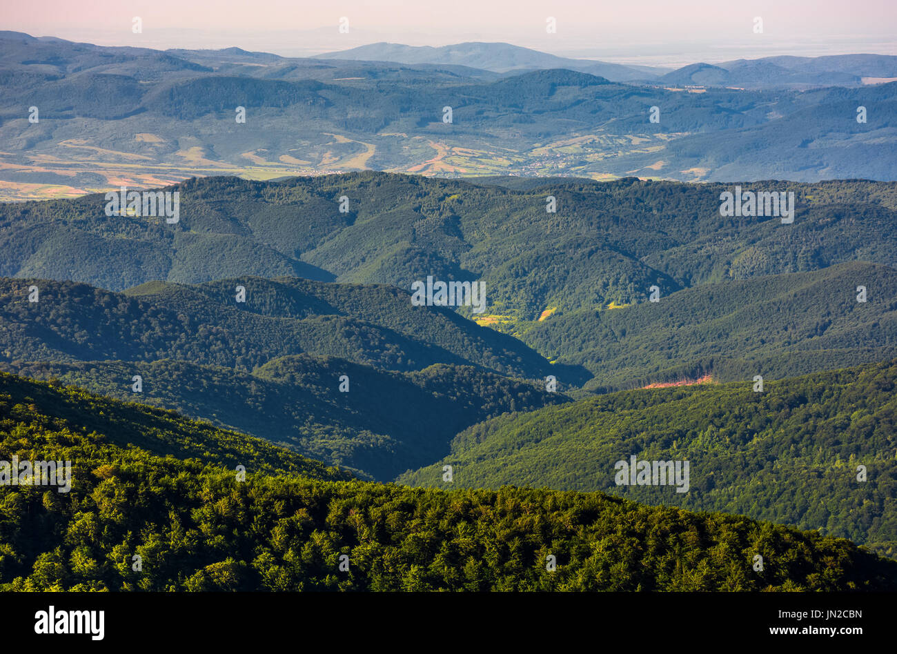 slope of mountain range with forest and on hillside. beautiful summer ...