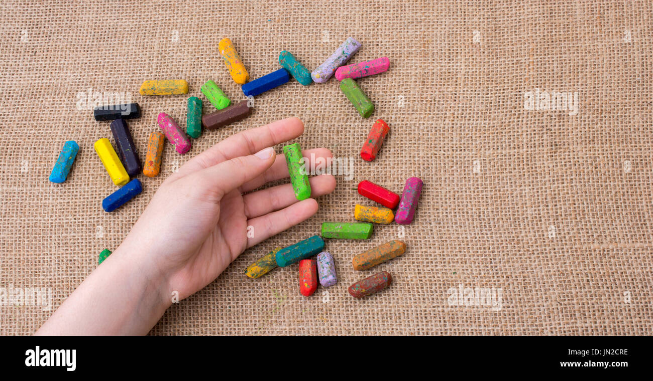 Used color crayons and a hand holding one Stock Photo - Alamy
