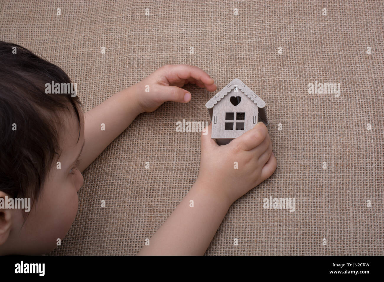 Child holding a model house on a linen canvas Stock Photo - Alamy