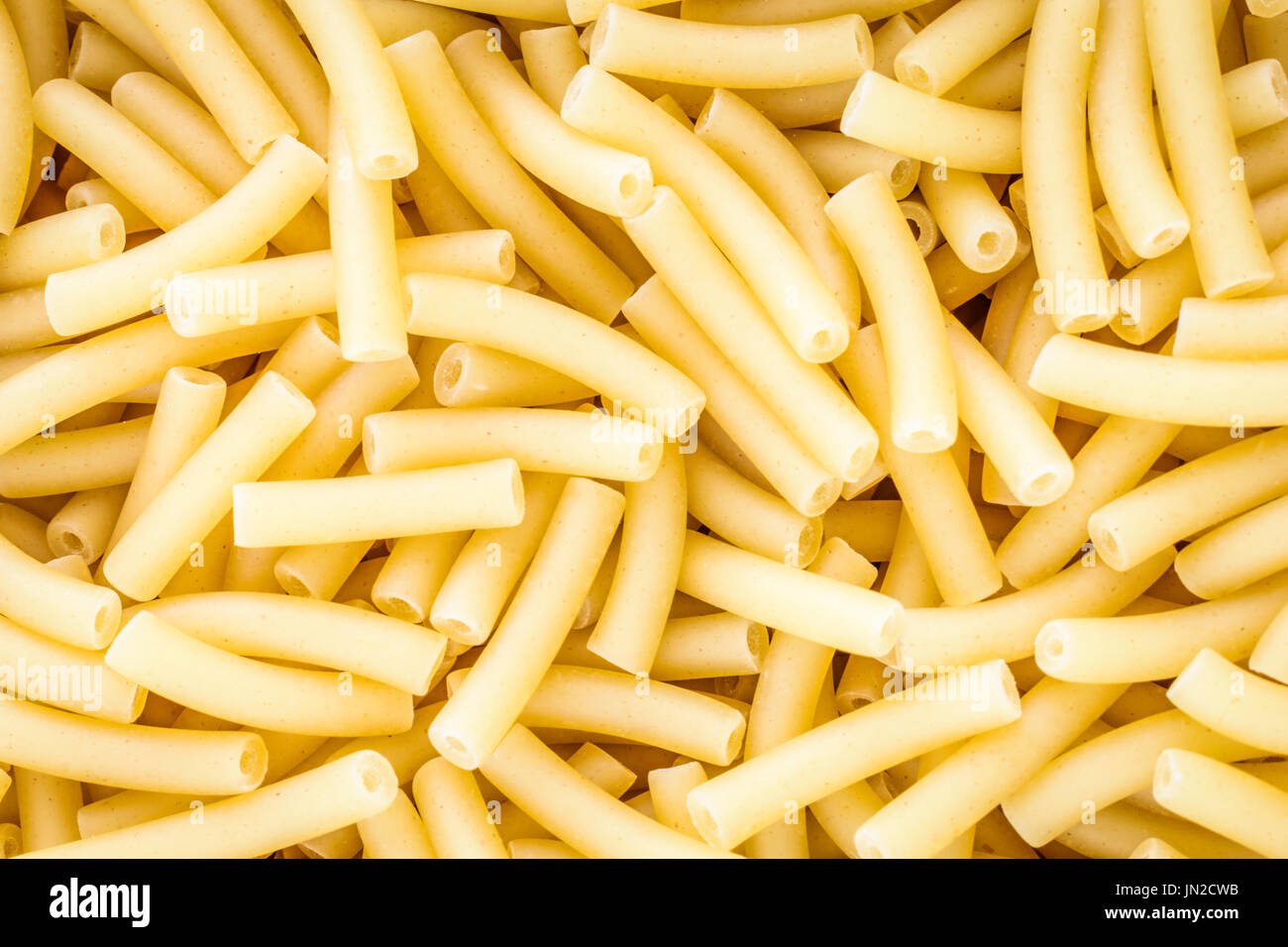 Raw Food Background. Closeup of uncooked yellow macaroni background ...