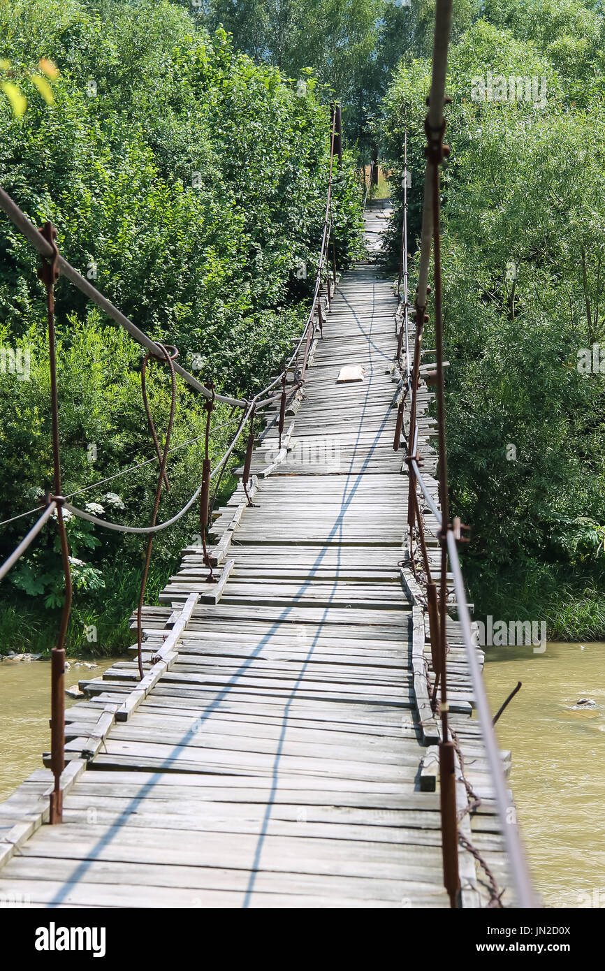 Suspended wooden bridge across Schodnica river in Carpathians, Ukraine ...