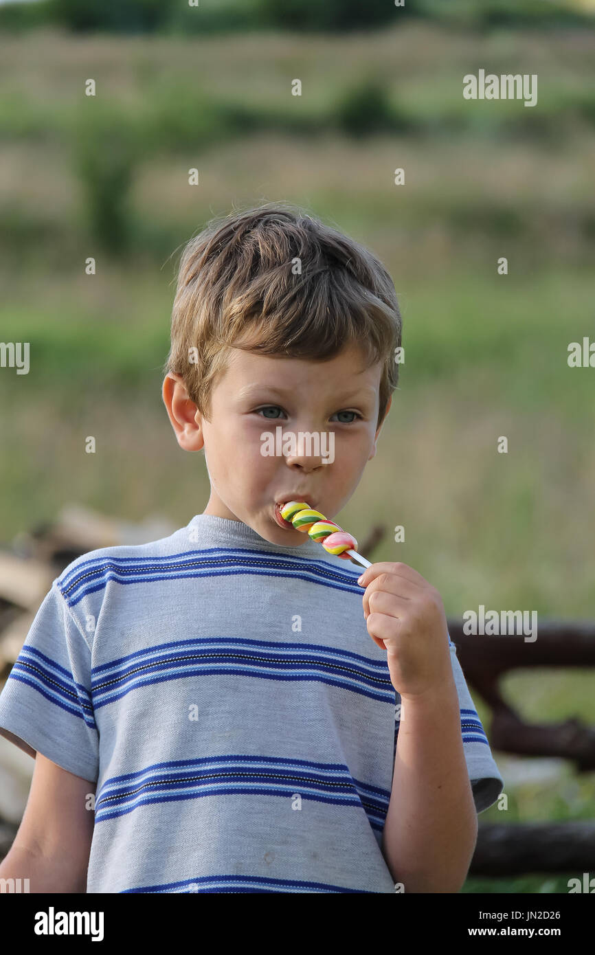 Handsome boy eats colorful candy Stock Photo - Alamy