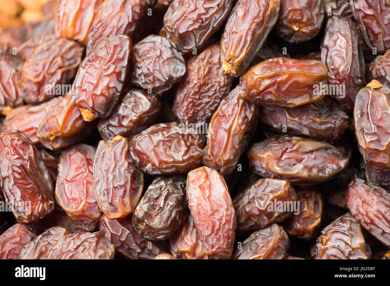 hand holding dates on a linen canvas background Stock Photo - Alamy
