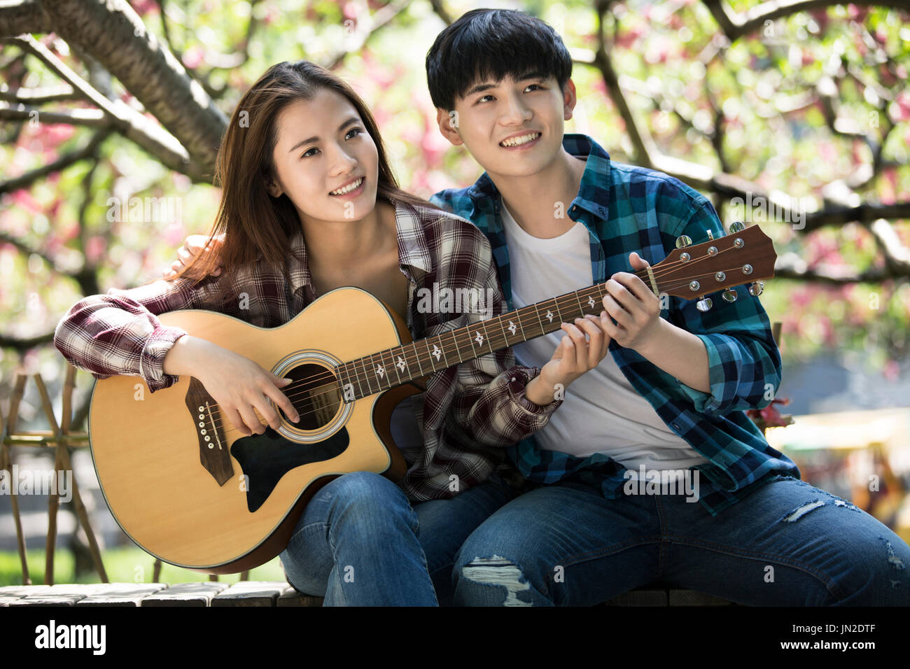Young couple playing the guitar Stock Photo - Alamy
