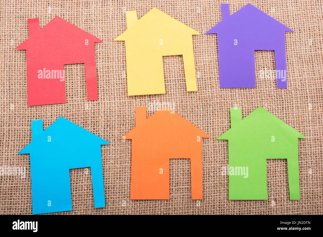 Little house shape cut out of colorful paper on a canvas background ...