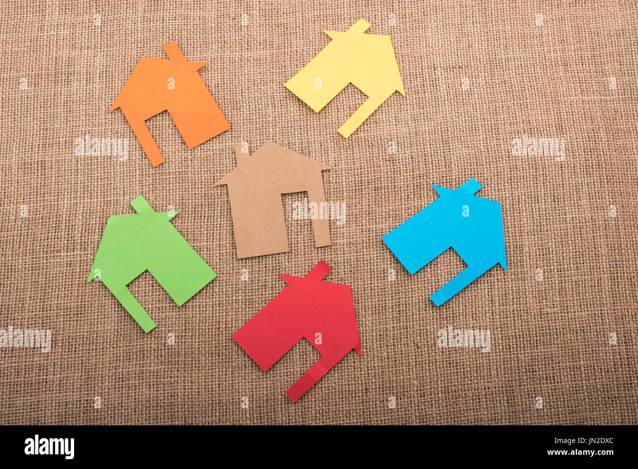 Little house shape cut out of colorful paper on a canvas background ...