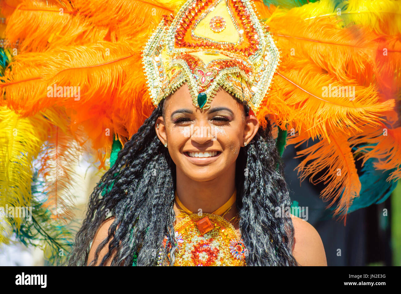 Smiling female performer wearing a colorful costume travelling through ...