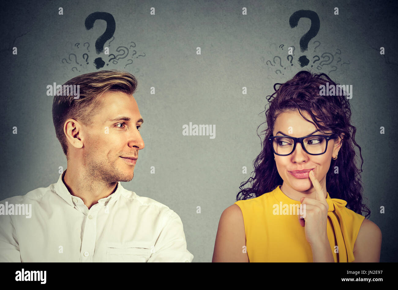 Man and woman with question mark looking at each other with interest ...