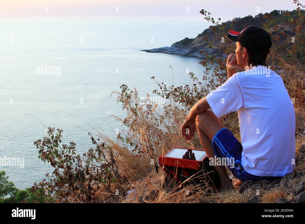 Lonely man looking with hope at horizon with sunlight during sunset ...