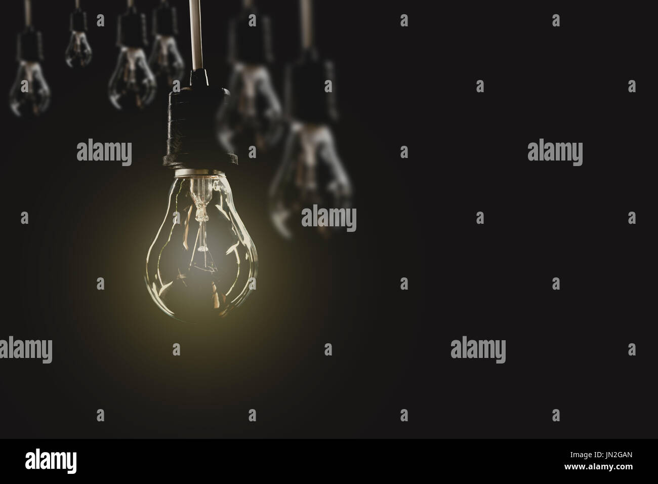 Hanging light bulbs with glowing one on dark background. Idea and ...